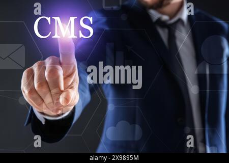 CMS. Man using virtual screen, closeup. Scheme with icons on dark ...