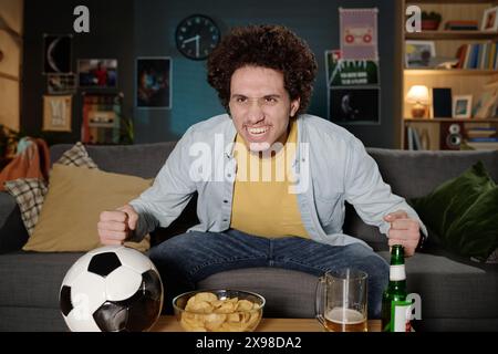 Young man watching tv late at night Stock Photo - Alamy