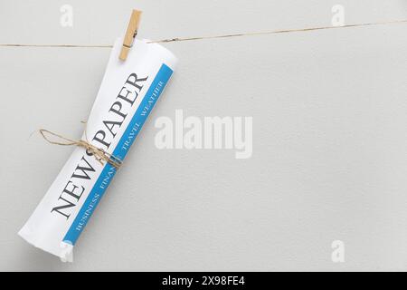Newspaper hanging on rope against white background Stock Photo - Alamy