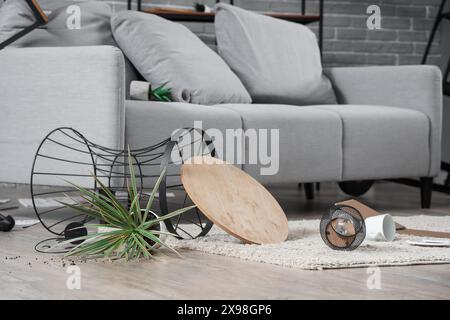Overturned table with lamp and plant on carpet in messy room Stock ...