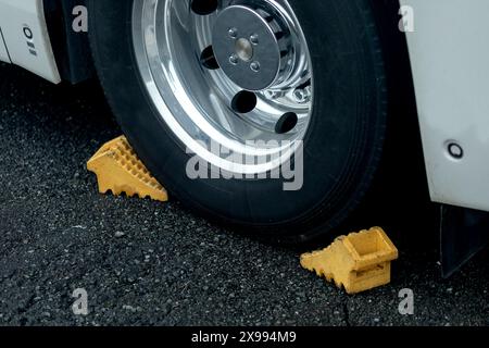 Close up of a wheel stopper for a passenger bus parked on an asphalt ...