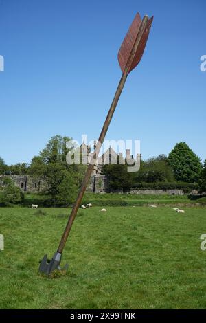A giant arrow at The Battle of Hastings site with Battle Abbey behind ...