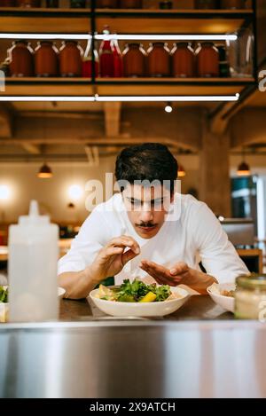 A chef bending and preparing food in a commercial kitchen Stock Photo ...