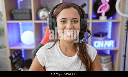 Young beautiful hispanic woman streamer smiling confident doing heart ...