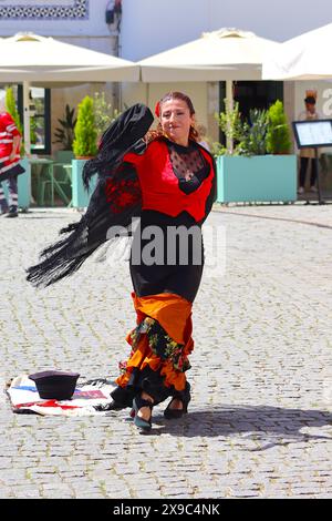 Under midday heat in a Lisbon tourist area, street performer Gloria ...