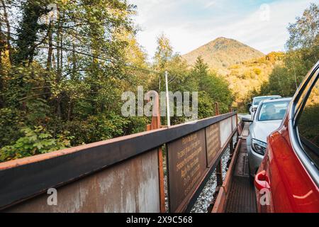 cars traveling on a motorail flatbed rail carriage down a mountain in ...