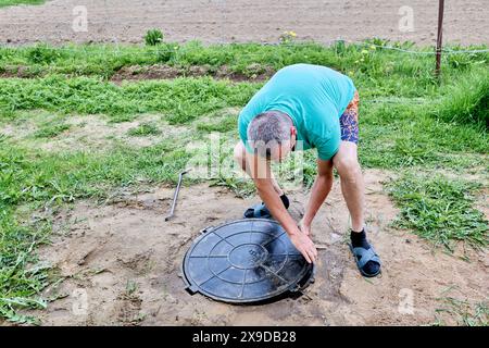 Manhole cover made of composite materials is removed from septic tank ...