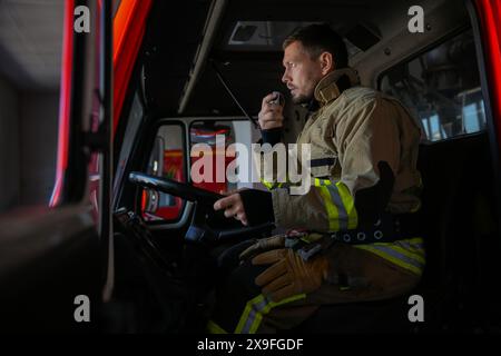 Firefighter using radio set while driving fire truck Stock Photo - Alamy
