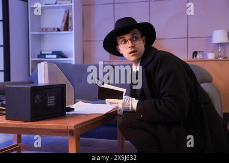 Male spy with magnifier inspecting place in office Stock Photo - Alamy