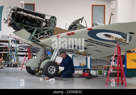 A engineer works on the restoration of a Spitfire wing inside the ...