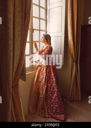 Woman wearing authentic Renaissance costome and headdress standing at ...