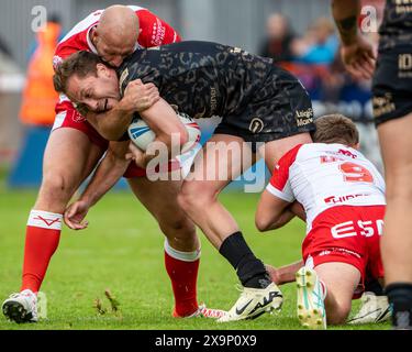 Jez Litten of Hull KR is tackled by Harry Smith of Wigan Warriors ...