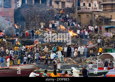 Traditional funeral pyres burn brightly as people gather along the ...