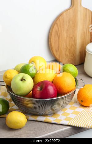 Metal colander with different fruits on countertop in kitchen Stock ...