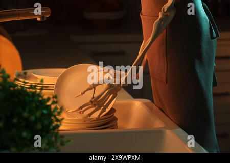 Human skeleton washing dishes in kitchen sink at night, closeup Stock ...