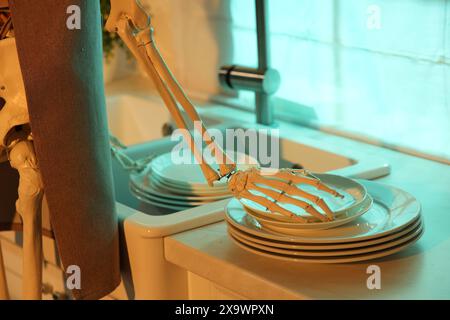 Human skeleton washing dishes in kitchen sink at night, closeup Stock ...