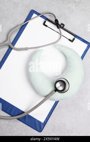 Clipboard, stethoscope and pillow on gray textured background, top view ...