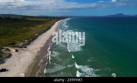 An aerial view of Uretiti Beach surrounded by green waters. New Zealand ...
