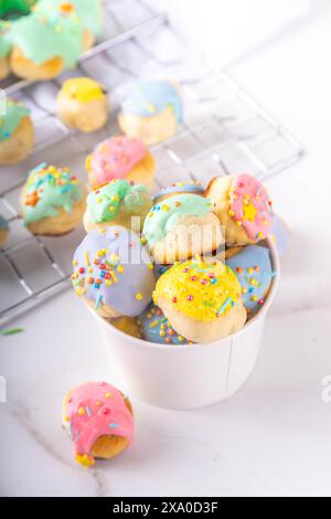 mini donuts with white glaze on pink background Stock Photo - Alamy