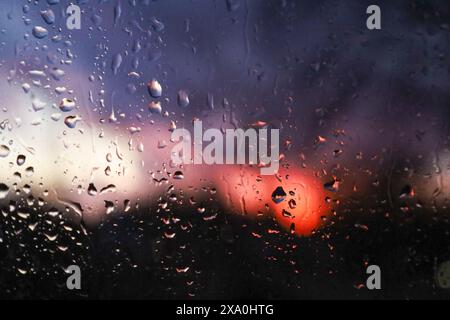 A view through a rain-streaked window. Raindrops adorn a window pane on ...