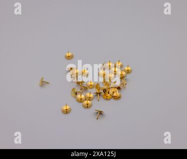 The golden push pins on a grey surface Stock Photo - Alamy