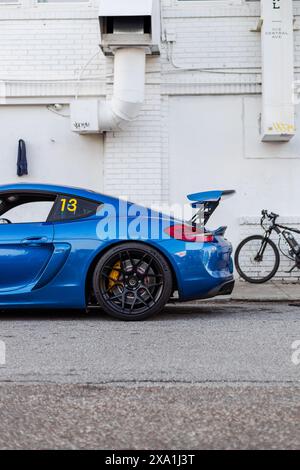 A vertical shot of a beautiful blue Porsche 981 Cayman GT4 race car ...