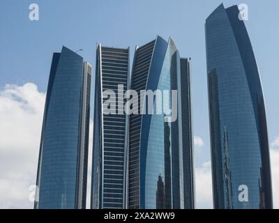 Modern skyscrapers with glass facades rise against a clear blue sky in ...