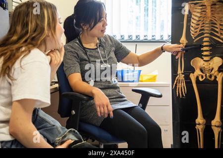 Asian woman medical professional teaching anatomy using laptop for ...