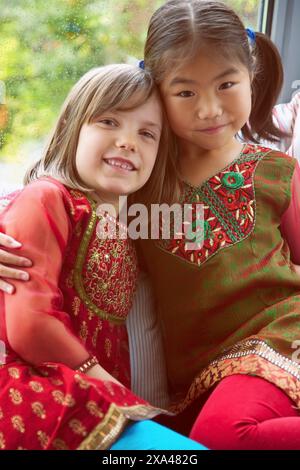 Two young Indian girls hugging a calf in a rural Indian village. Andhra ...