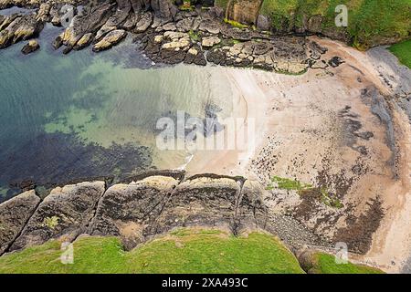 sandy sea beach with rocks and low tide in overcast day in autumn ...