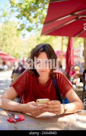 Focused adult Woman sitting at table and making cutout while working in ...