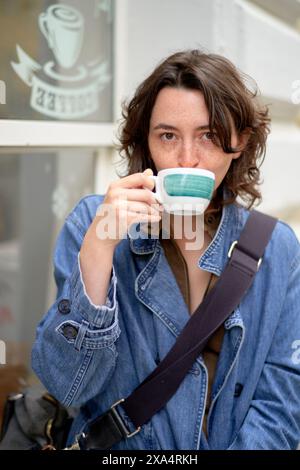 Young adult woman enjoying a coffee break at a modern cafe Stock Photo ...