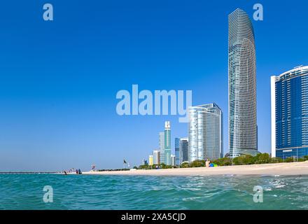 city skyline with modern skyscrapers, sandy beach, and an active ocean ...