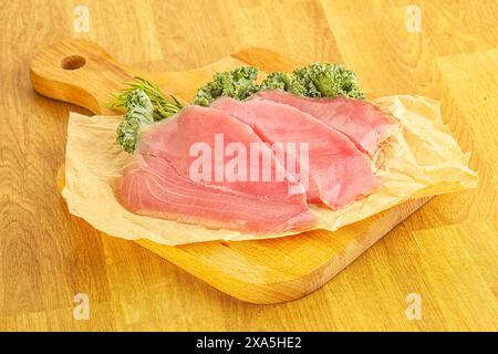 Raw salted tuna slice over board snack Stock Photo - Alamy