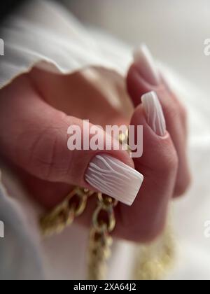 Close up of chic woman's hands holding decorated pink present and ...