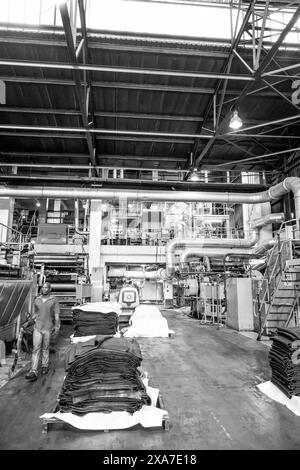 A monochrome of machinery in a factory used for rubber assembly line in ...