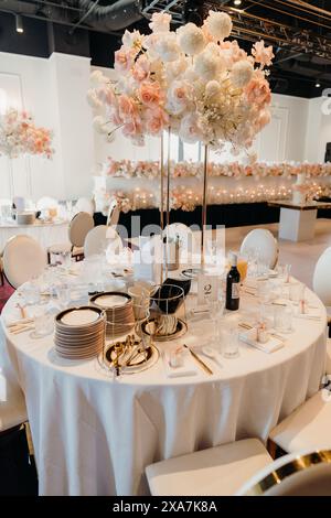 Elegant banquet hall with floral centerpieces, table settings, dramatic stage lighting for ...