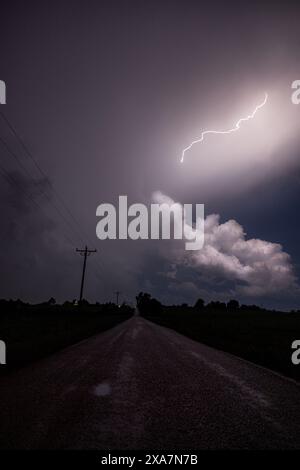 A lightning strike behind power lines during an intense midwest April ...