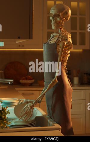 Human skeleton washing dishes in kitchen sink at night Stock Photo - Alamy