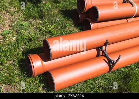 Plastic pipes for external sewerage lay in a row, elements of outdoor ...