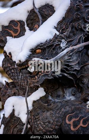 A menacing dragon statue covered in snow at the ancient sacred ...