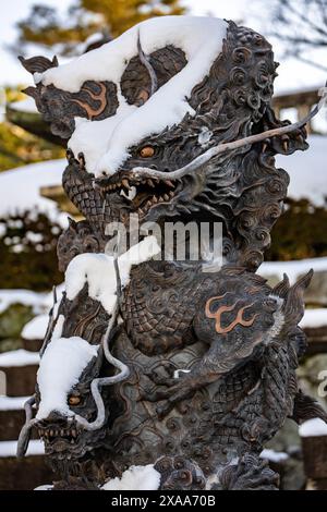 A menacing dragon statue covered in snow at the ancient sacred ...