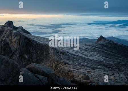 Sun sets on rocky terrain with mist rising Stock Photo - Alamy
