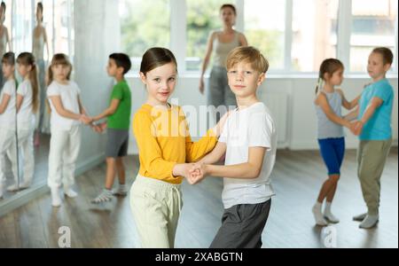 Preteen children learn to dance tango under guidance of a teacher in ...