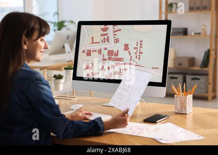 Cartographer working with cadastral maps at table in office Stock Photo ...