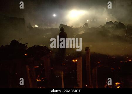 A firefighter performing the cooling phase after a fire accident burned ...
