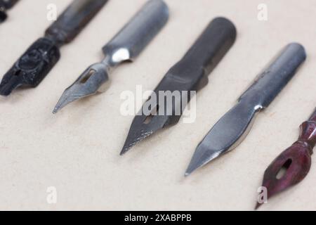 Metal nibs on an antique textured paper background Stock Photo - Alamy