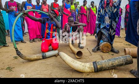 Men making music from cow horns at a traditional Dinka wedding, Bor ...
