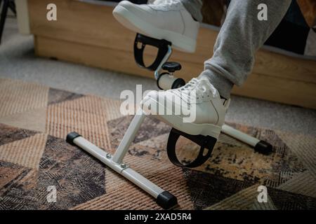 Person Using White Peddler Exercise Machine While Sitting Stock Photo ...