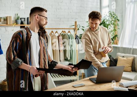 Two men in designer workshop, collaborating on trendy attire Stock ...